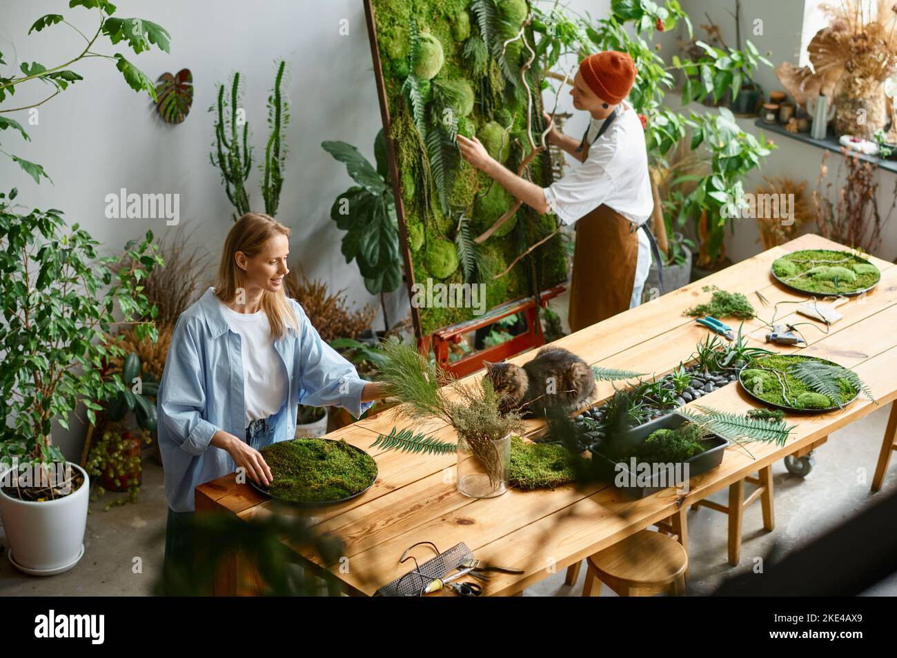 Florist and decorator making handicraft artwork from plants overhead ...