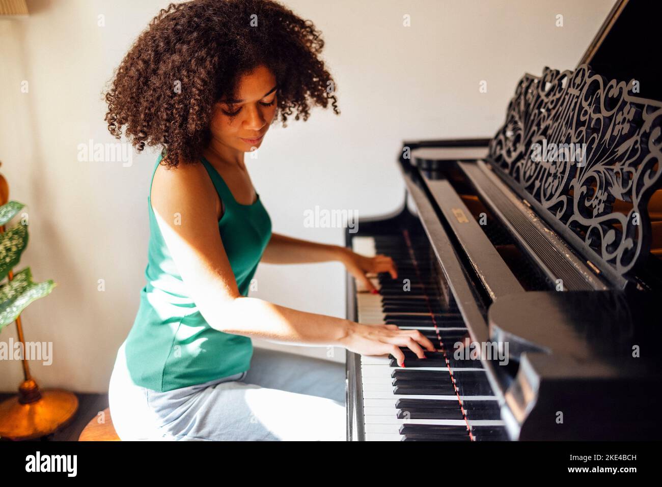 Young black lady playing a piano. Happy smiling woman enjoy fun ...