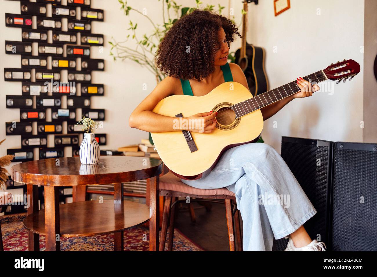 Smiling afro americal young woman playing acoustic guitar. Girl playing ...