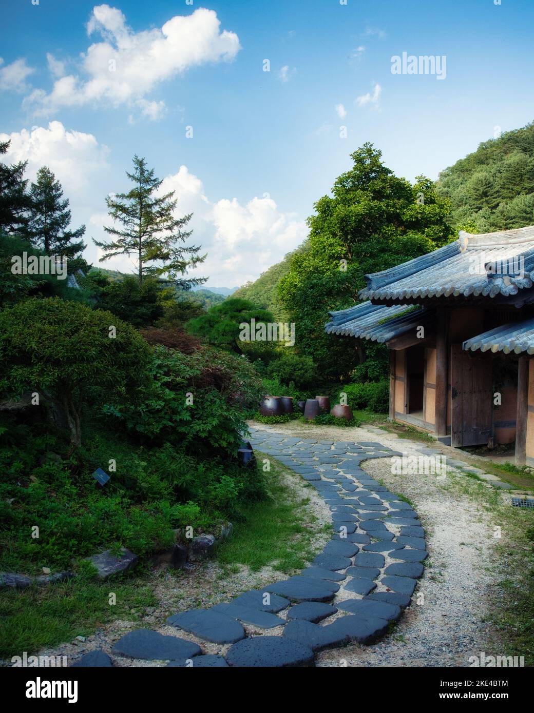A stone walkway in front of a traditional Korean house in the Garden of ...