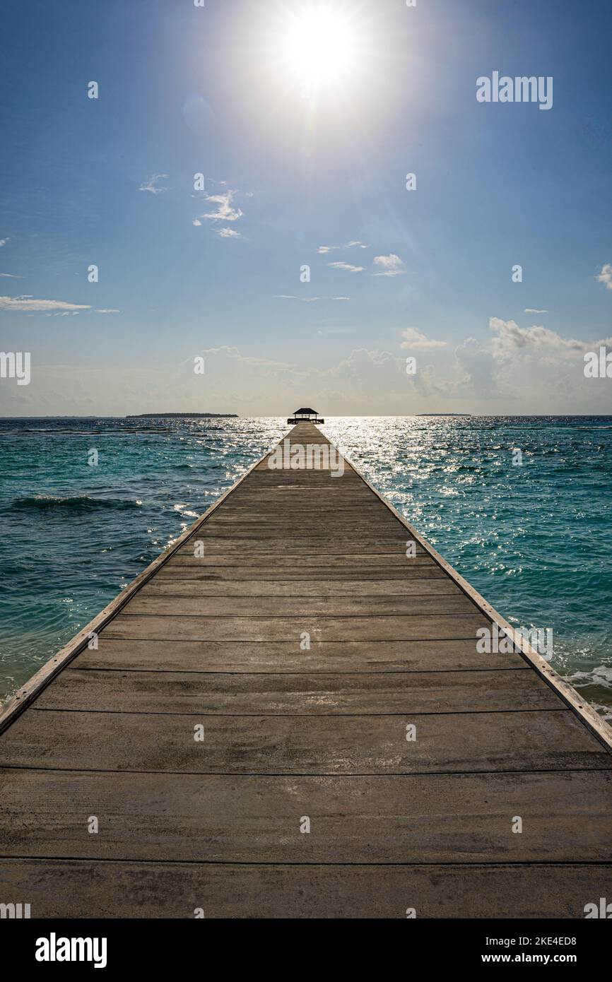 Beautiful jetty with centered sun and horizon. Taken in the Maldives ...