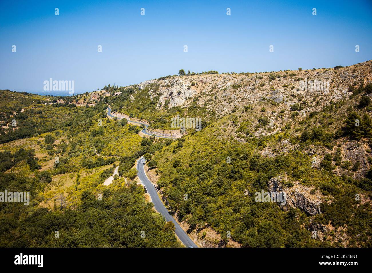 A drone view of a wavy asphalt road in the green forest Stock Photo - Alamy