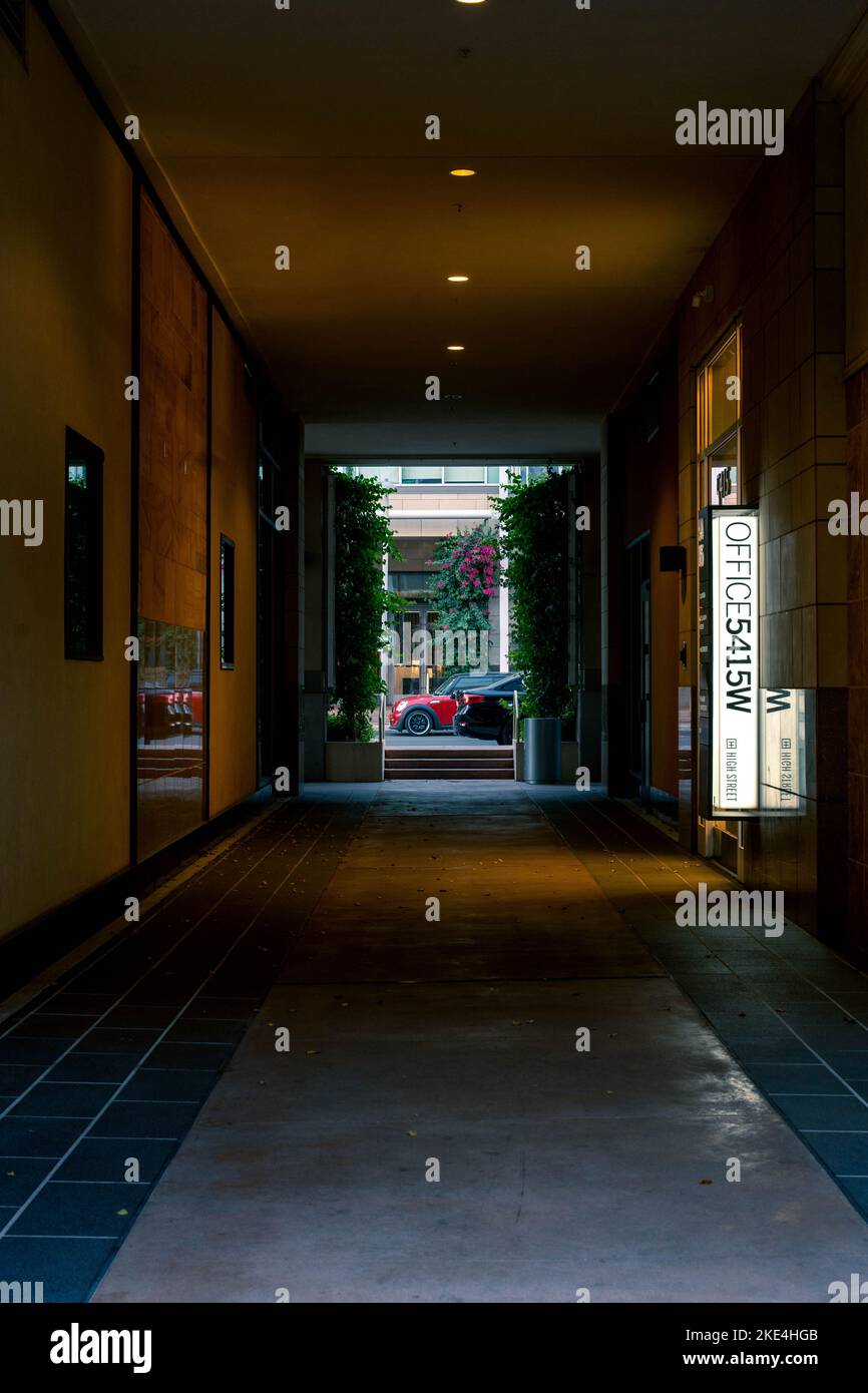 A vertical shot of looking down a hallway at high street with a red car ...
