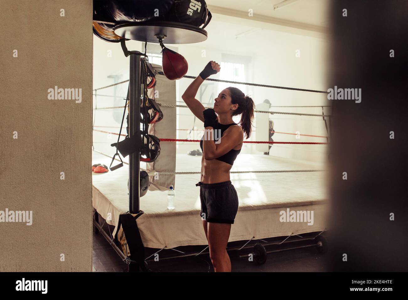 Female athlete training with a small punching bag in a boxing gym ...