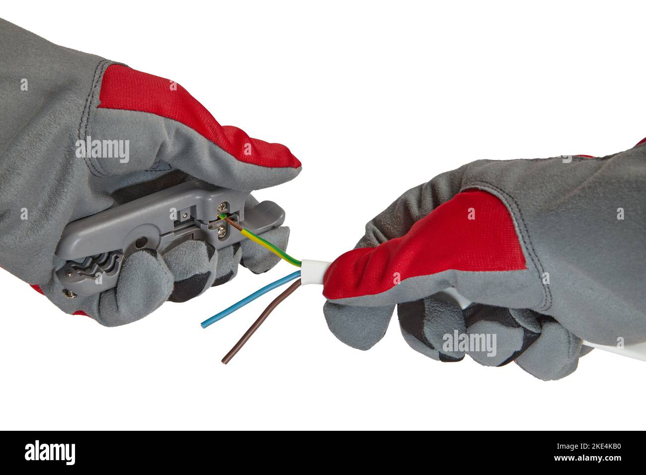 Electrician removes insulation from a three-core copper wire with a ...