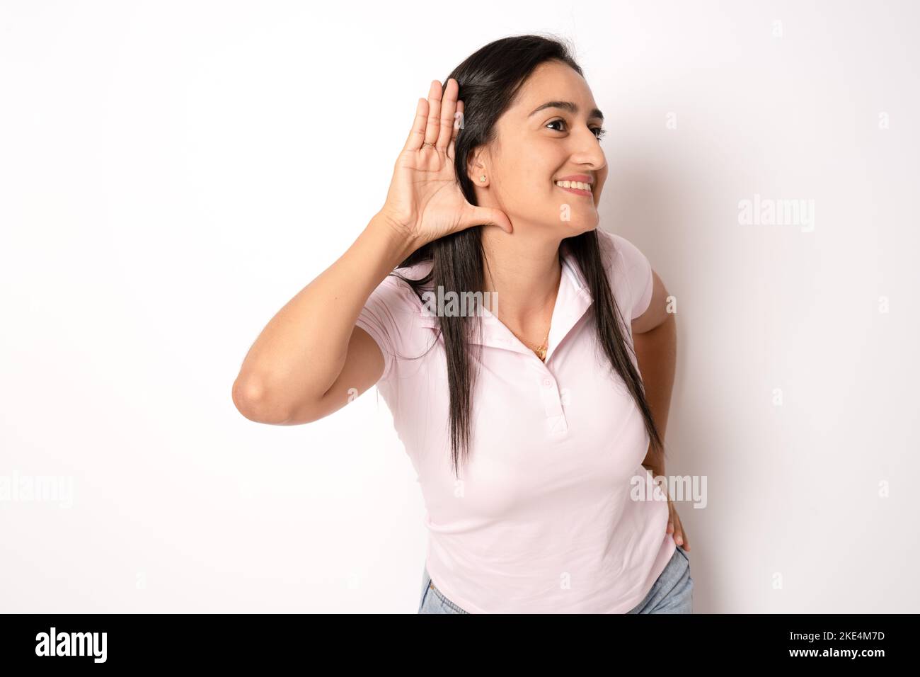 Young brunette woman over isolated white background listening to ...