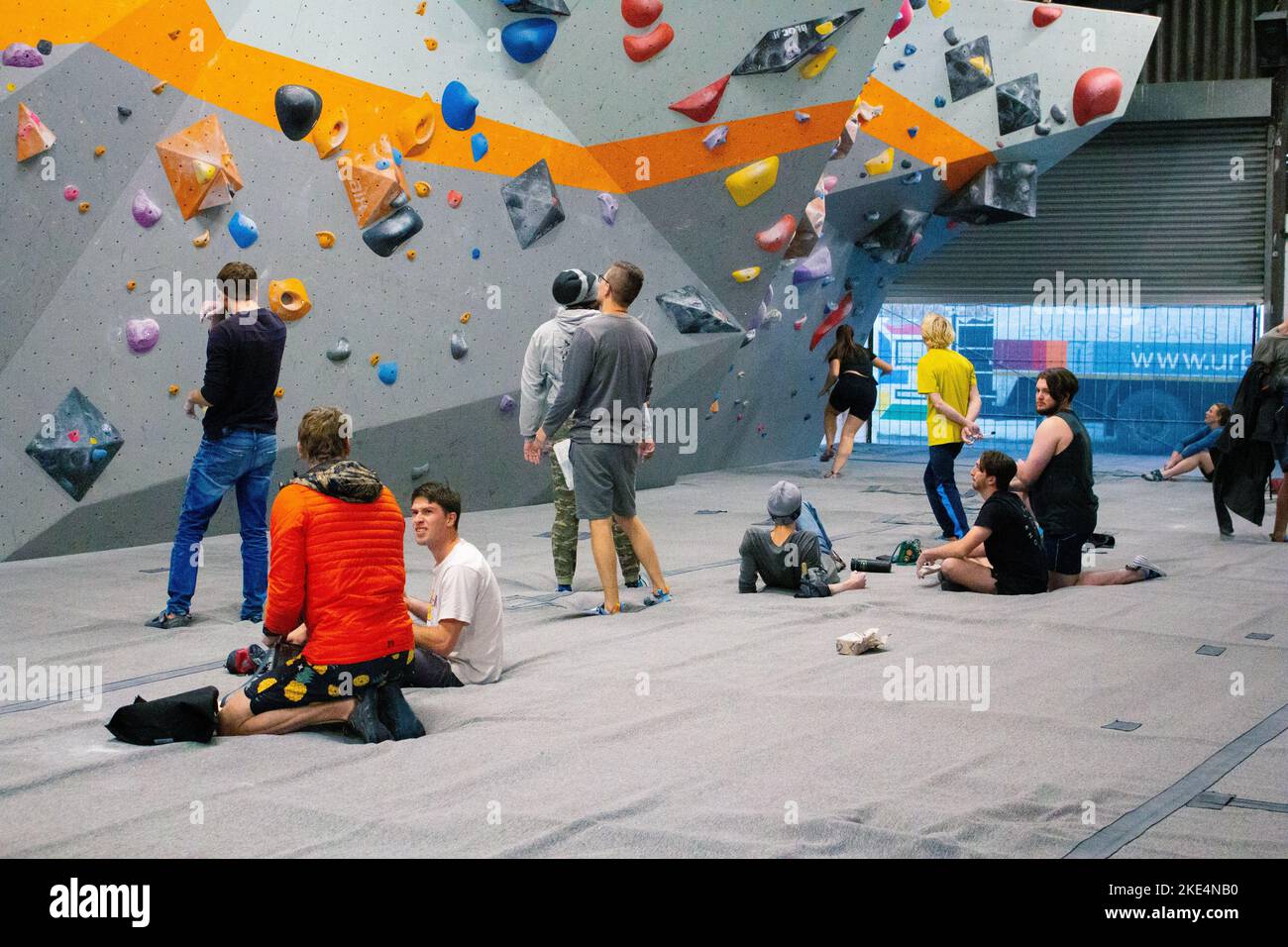 A group of rock climbers hanging in front of the climbing wall with ...