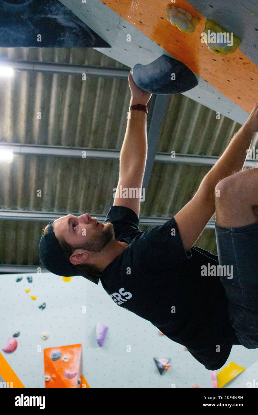 The handsome rock-climber bouldering on colorful slopers on the ...