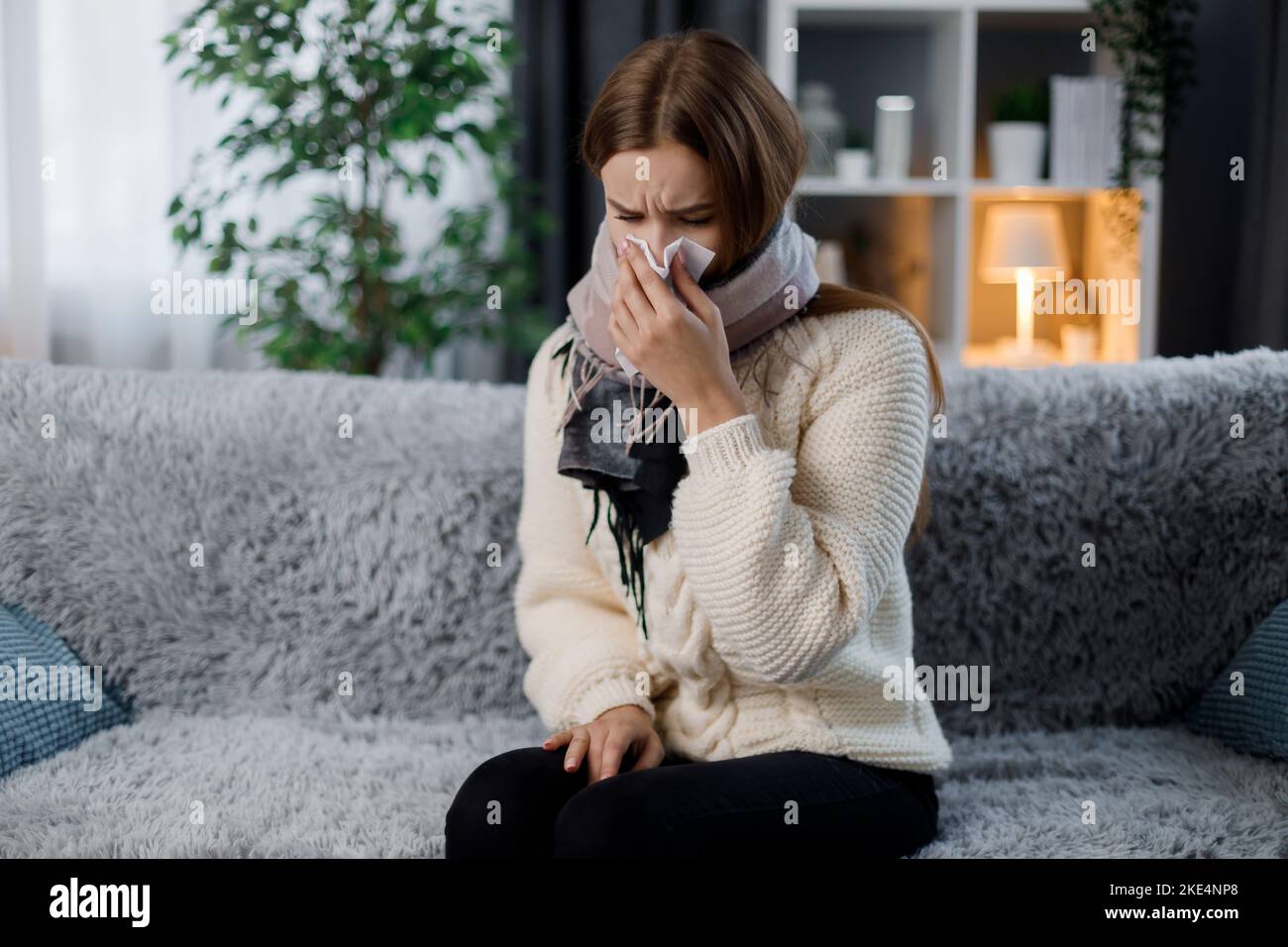Woman blowing nose with tissue Stock Photo - Alamy