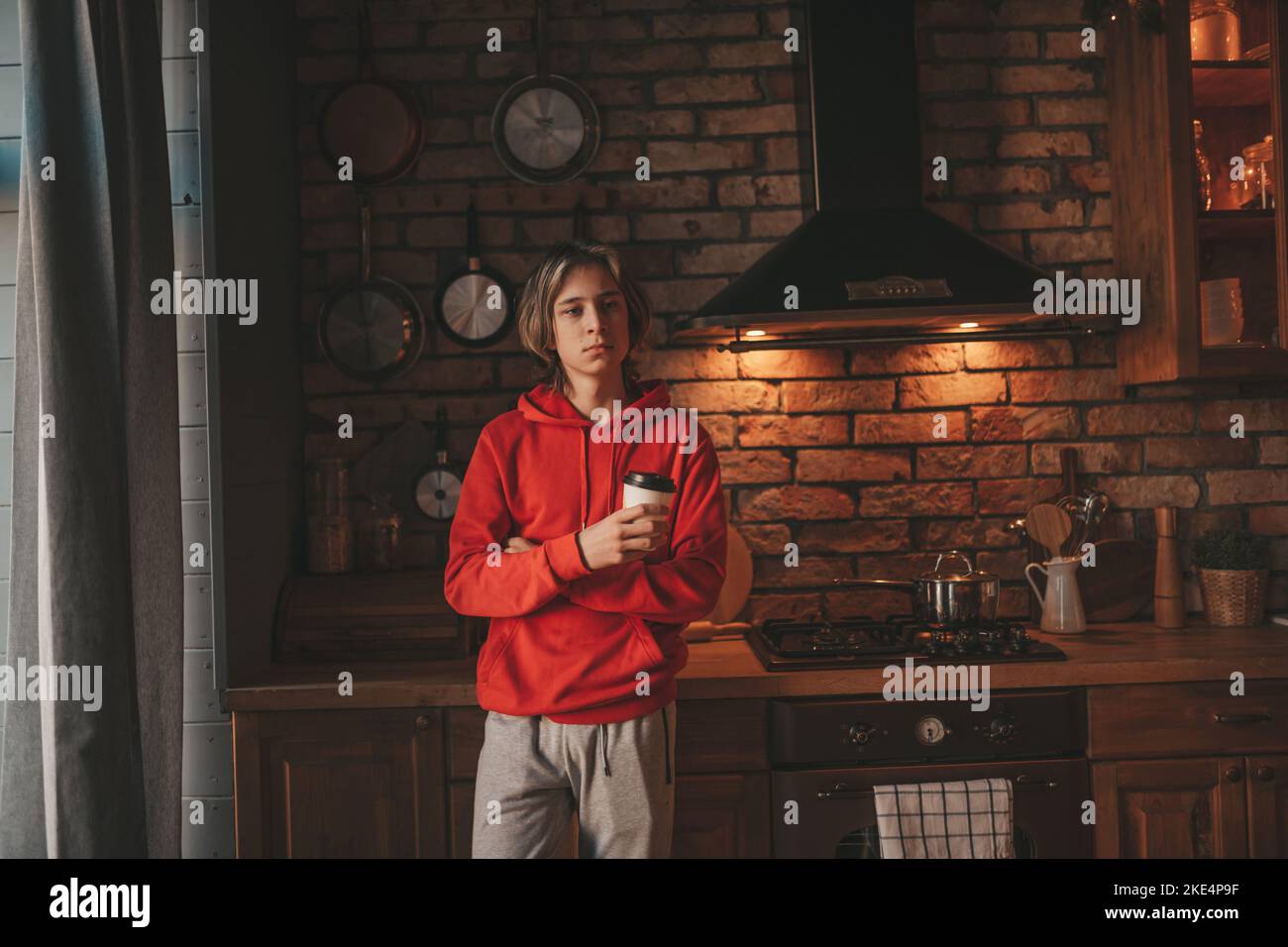 Young teen boy with long hair thoughtful look sad eyes negative mood ...