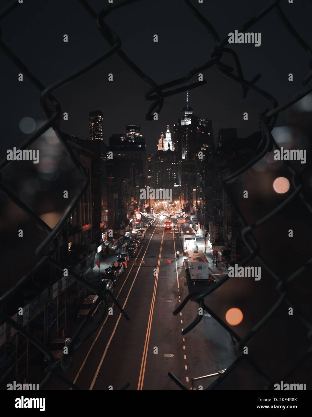 A view of a big long street in a huge city at night through a broken ...