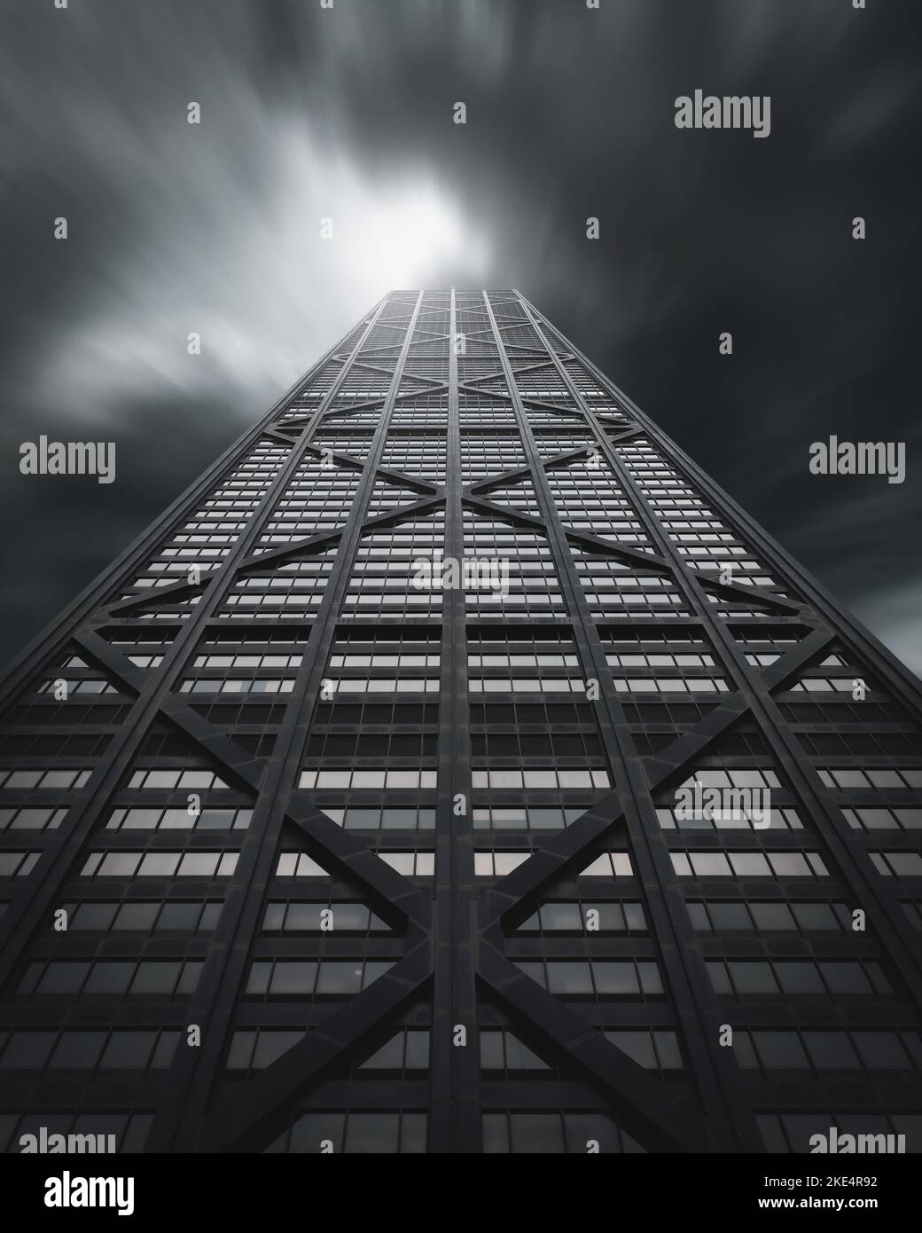 A front view from the street of a tall skyscraper facade with stormy ...