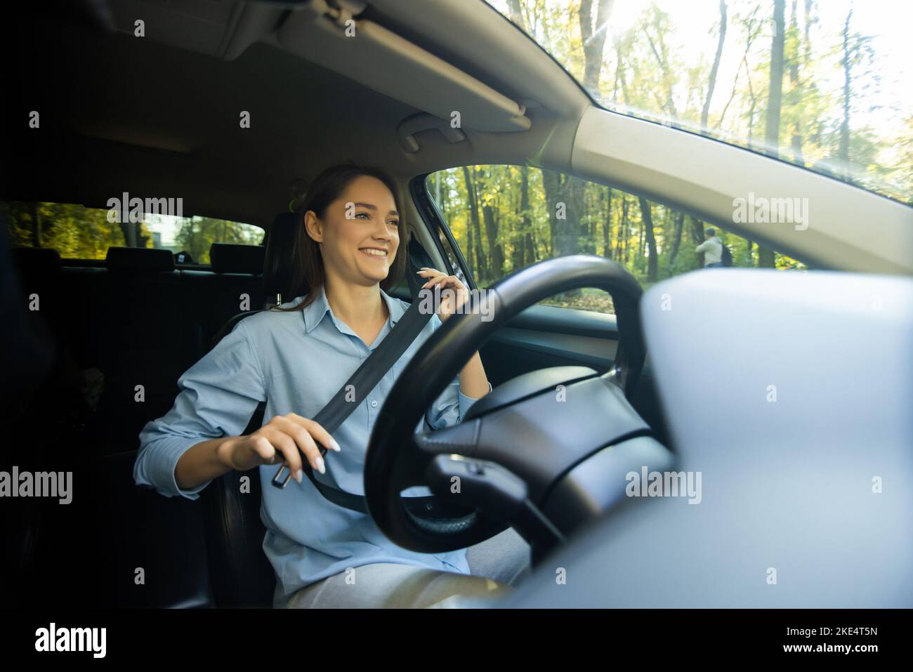 Safety first. Beautiful caucasian lady fastening car seat belt. Pretty ...