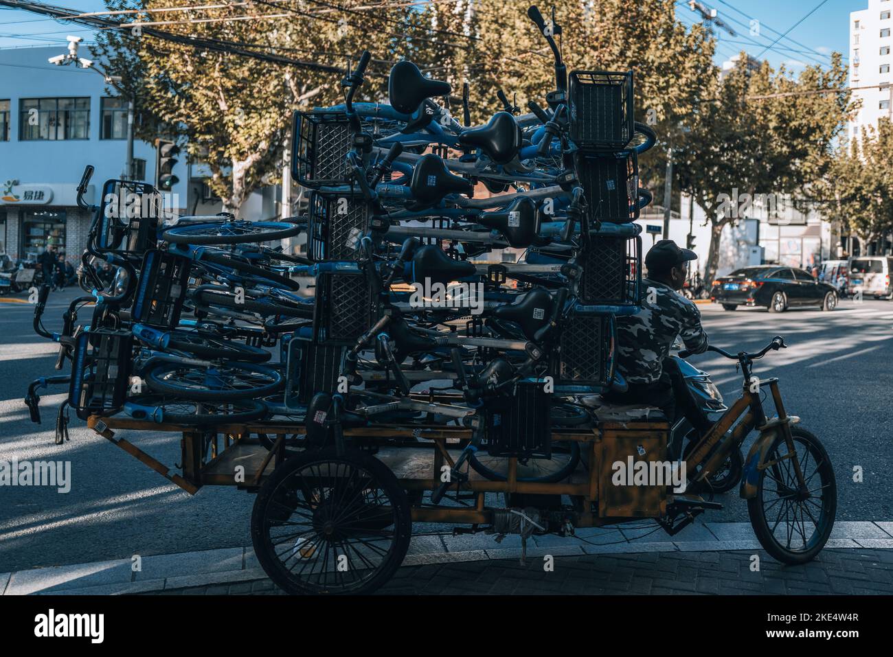 A tricycle relocating the unused bikes in the streets of Shanghai with ...