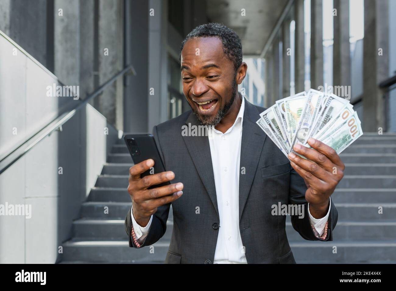 Happy african american businessman outside office building celebrating ...