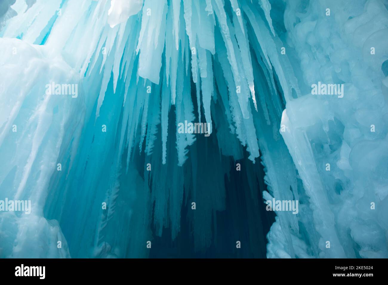 A low angle of an ice formation with hanging huge icicles Stock Photo ...