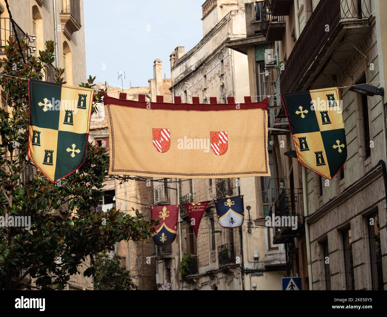 The flags of Medieval festivals hanging between buildings in Tortosa ...