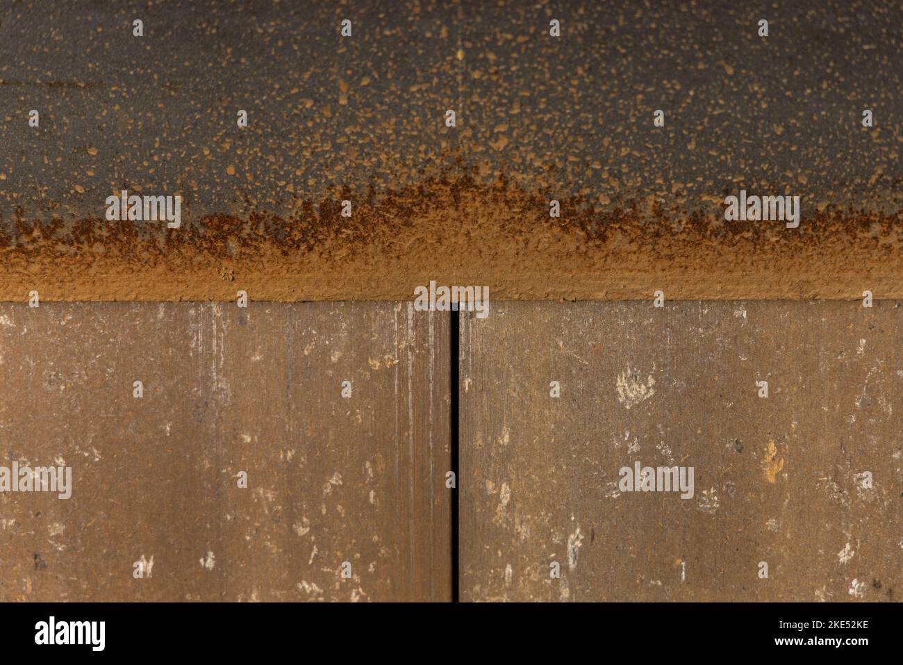 3 plates of worn, rusted metal come together to form an intersecting ...