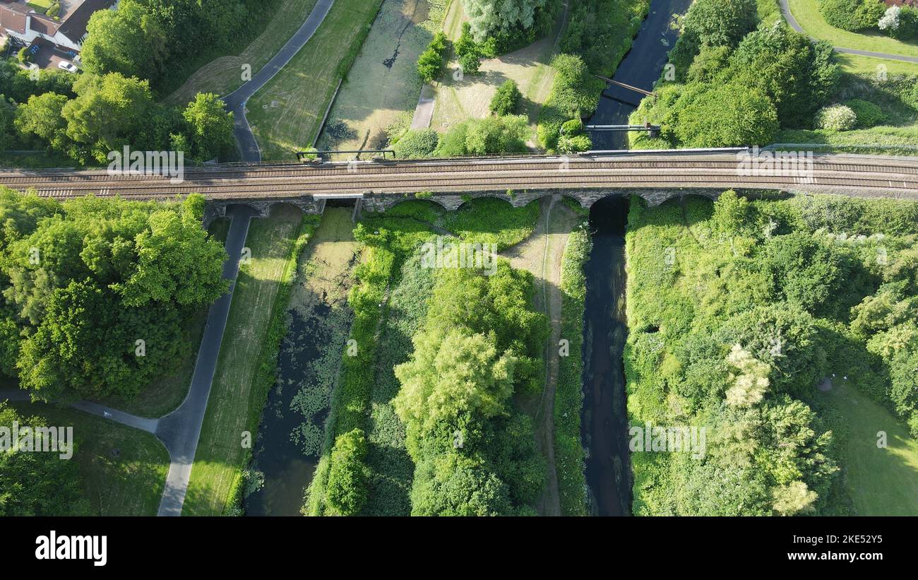 An aerial shot over a railway viaduct over a pair of parallel canals ...