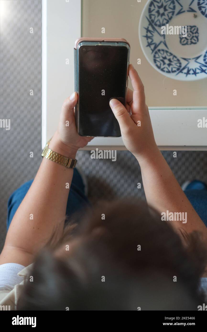 overhead close up shot of hands using a mobile phone Stock Photo - Alamy