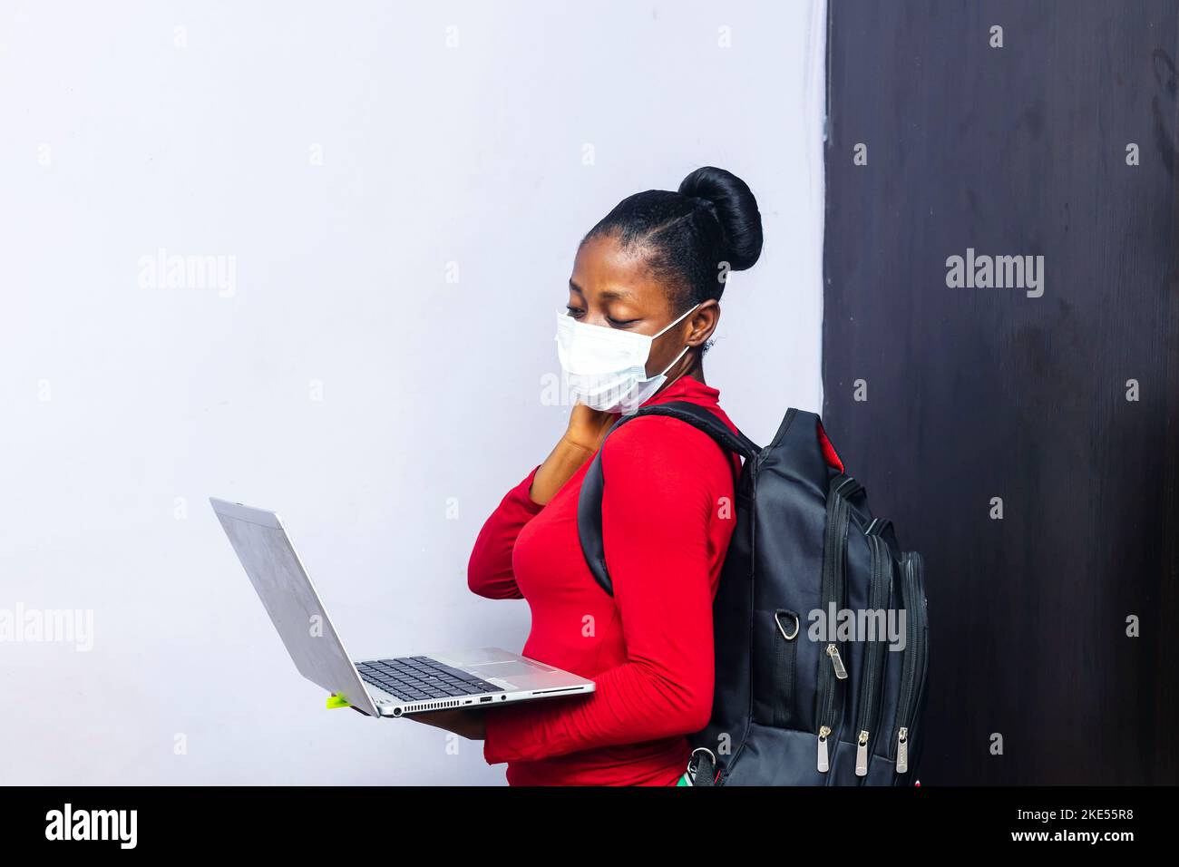 A young attractive African college student wearing a face mask standing ...
