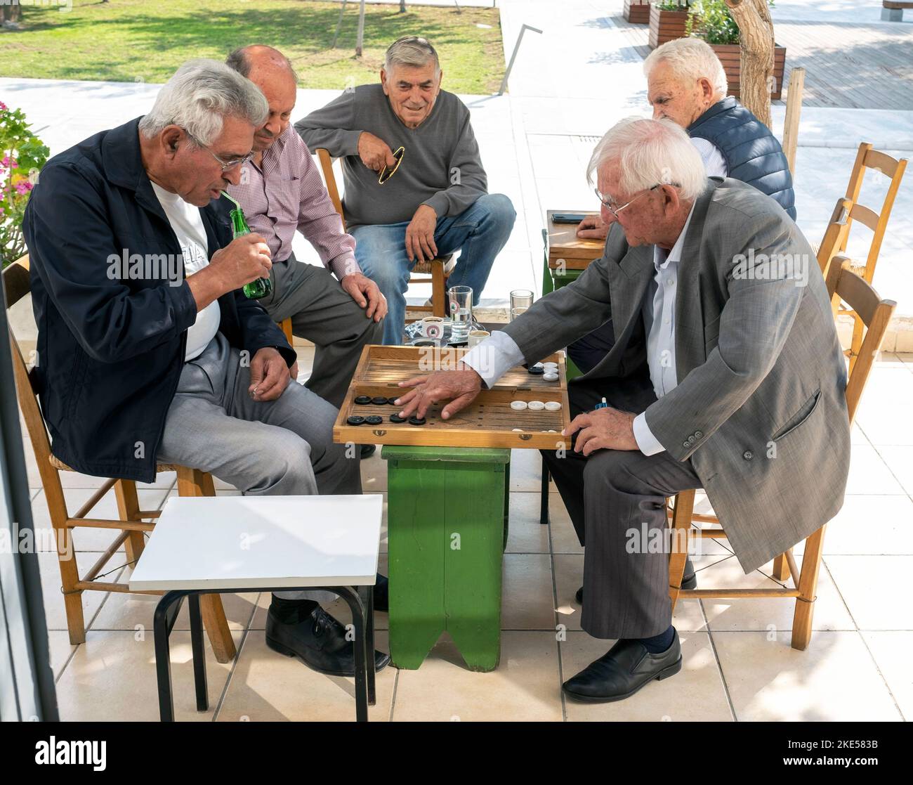 A group of senior men playing backgammon board game, Pafos town centre ...