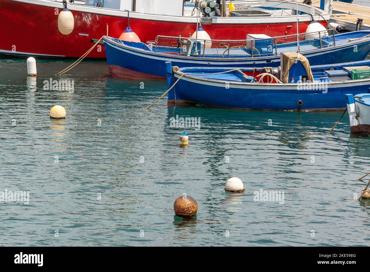 A shot of blue classic fishing boats side by side hanging in the dark ...