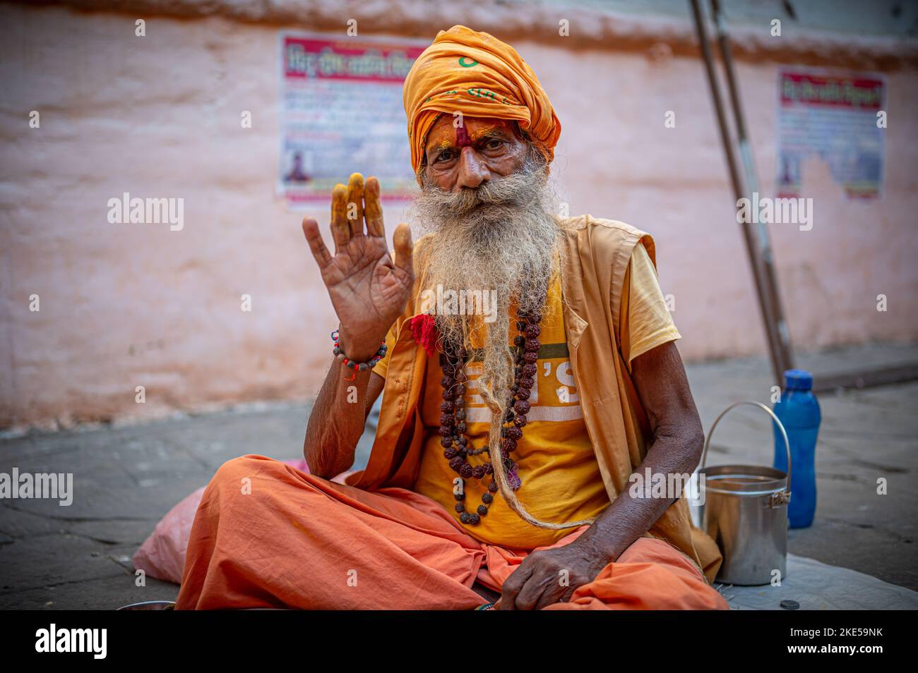 An Indian Godman in a traditional costume sitting on a sidewalk on the ...