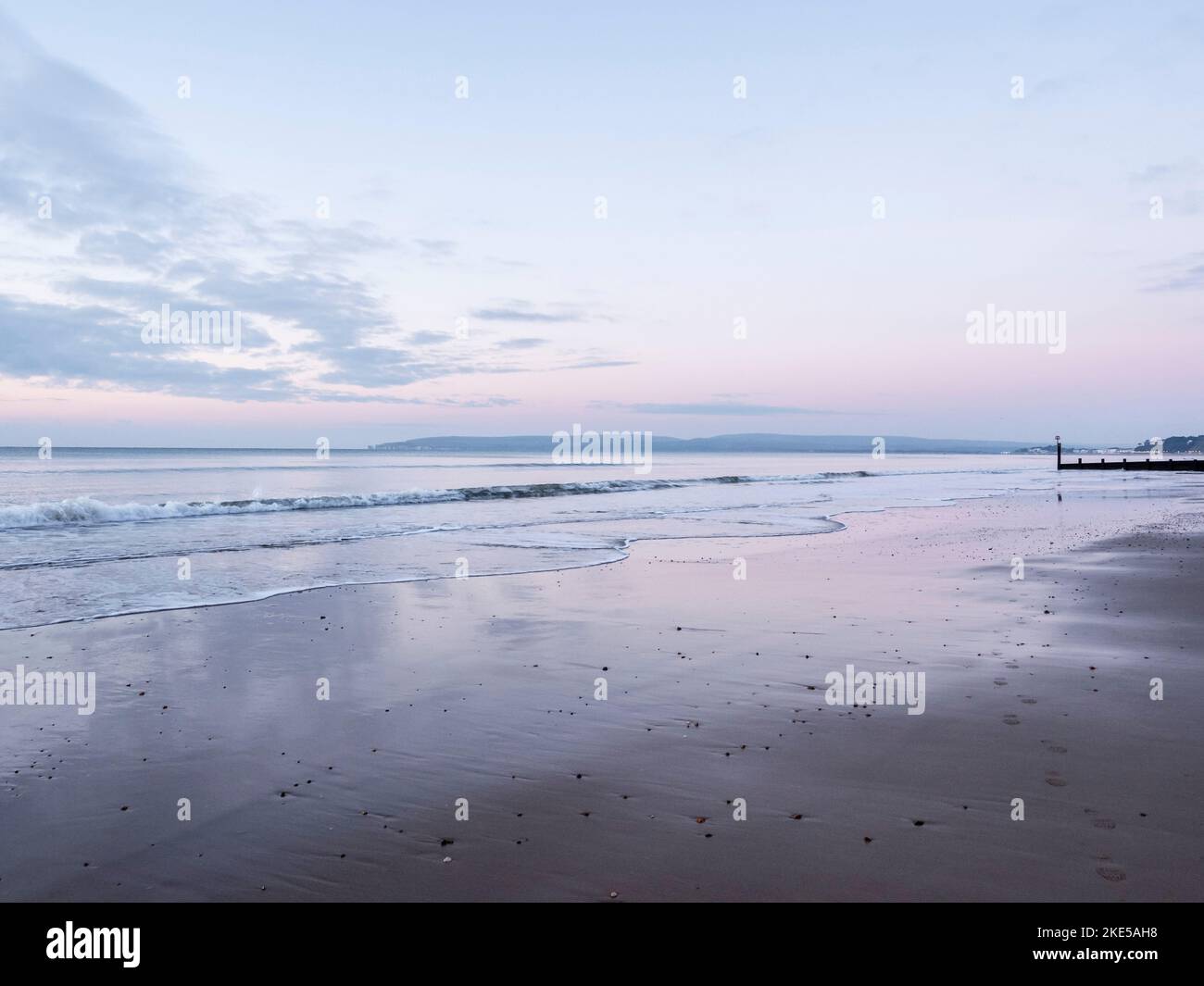 Dawn on the beach looking towards Old Harry Rocks and Purbeck Coast ...