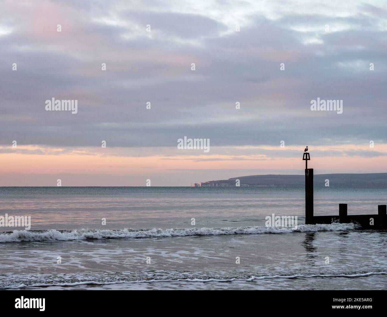 Dawn on the beach looking towards Old Harry Rocks and Purbeck Coast ...