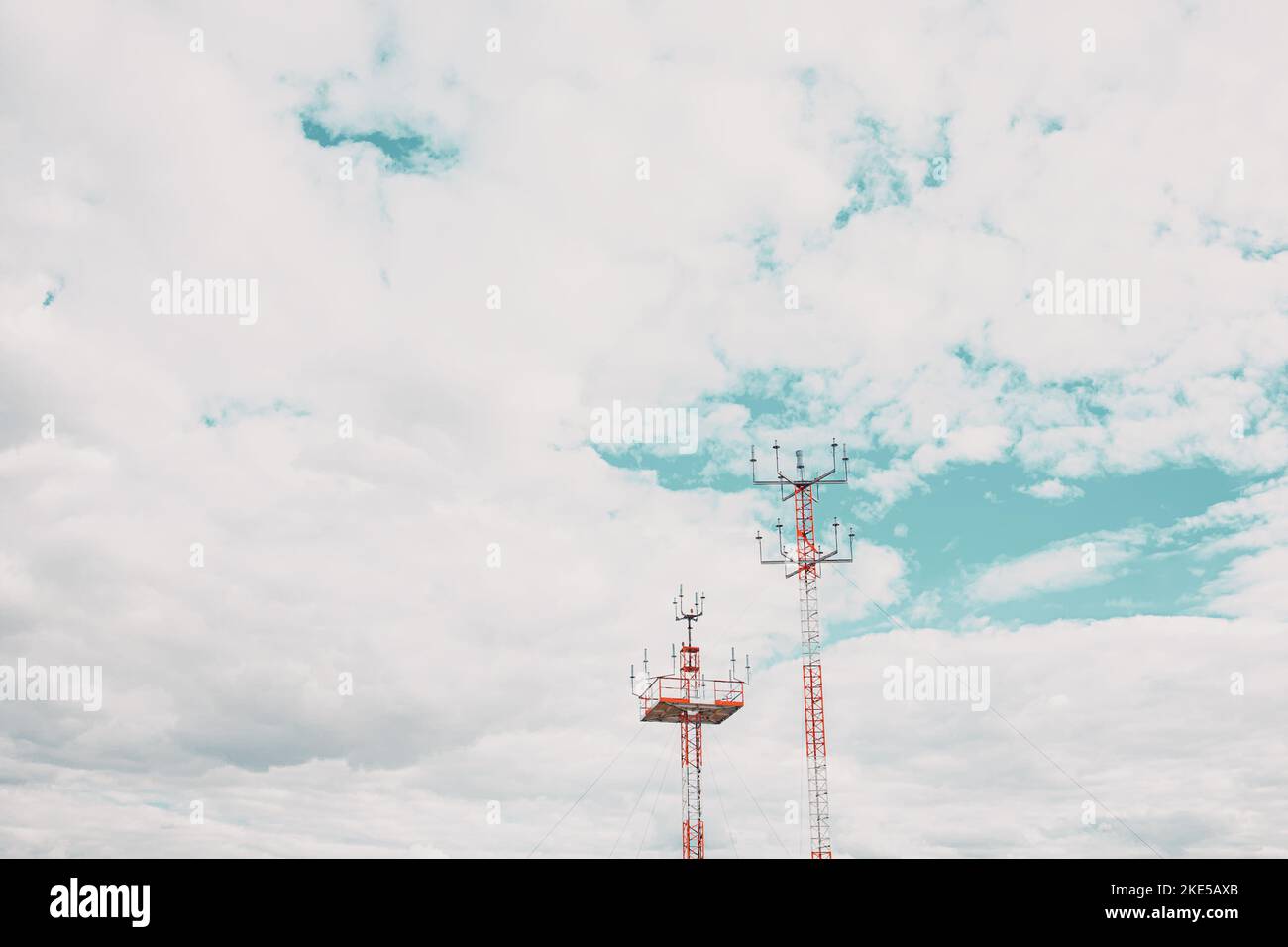 A low angle of telecommunication tower against a cloudy sky with fluffy clouds Stock Photo - Alamy