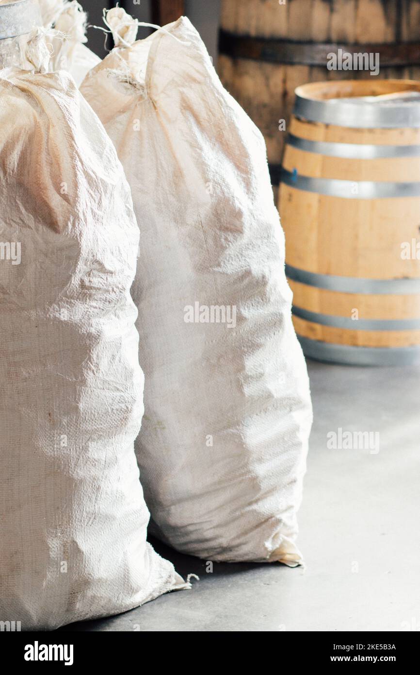 poly bags of ingredients next to whiskey barrels on concrete floor ...