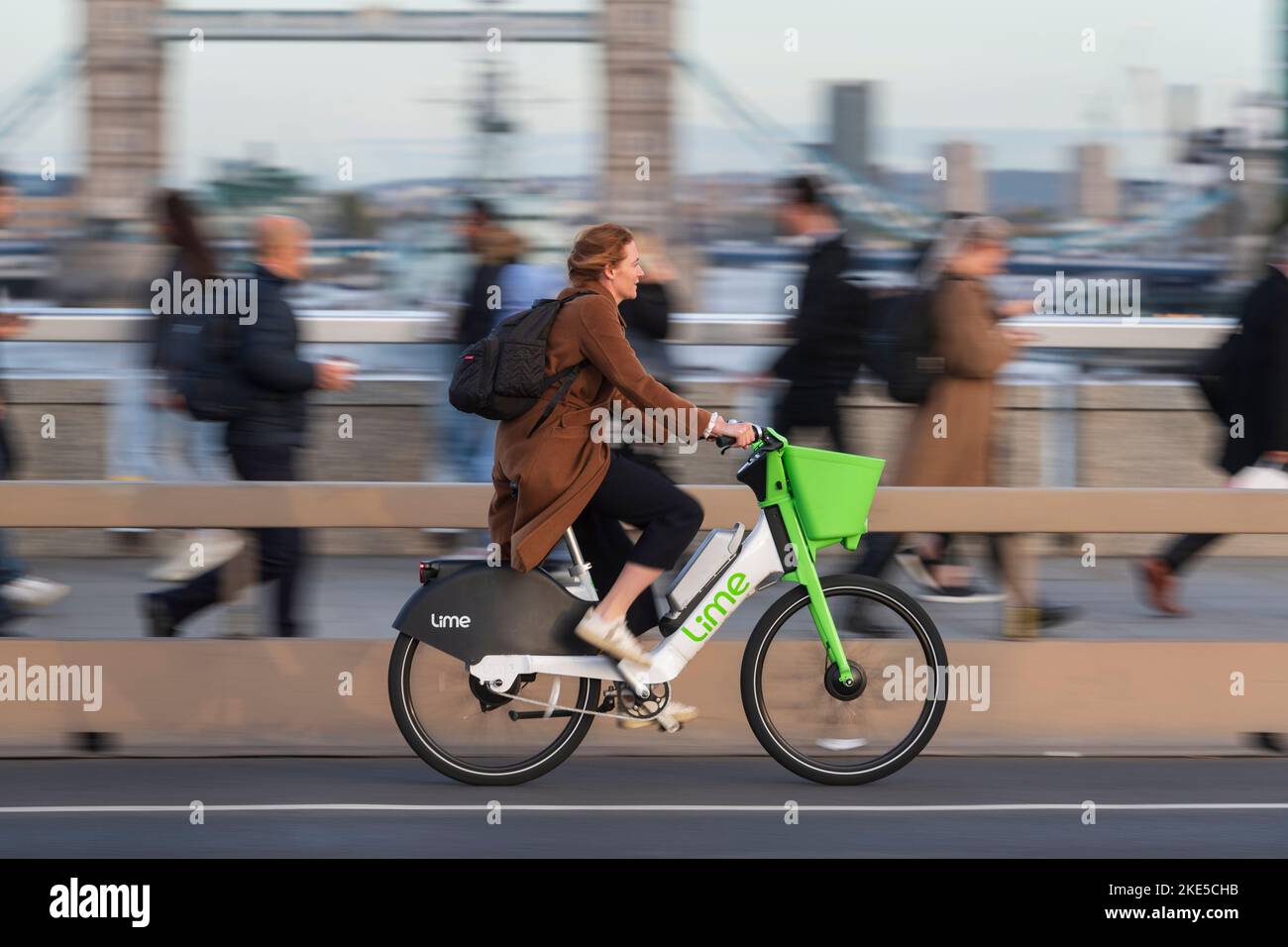 A man commuting on a Lime electric hire bike across London Bridge during rush hour. London ...