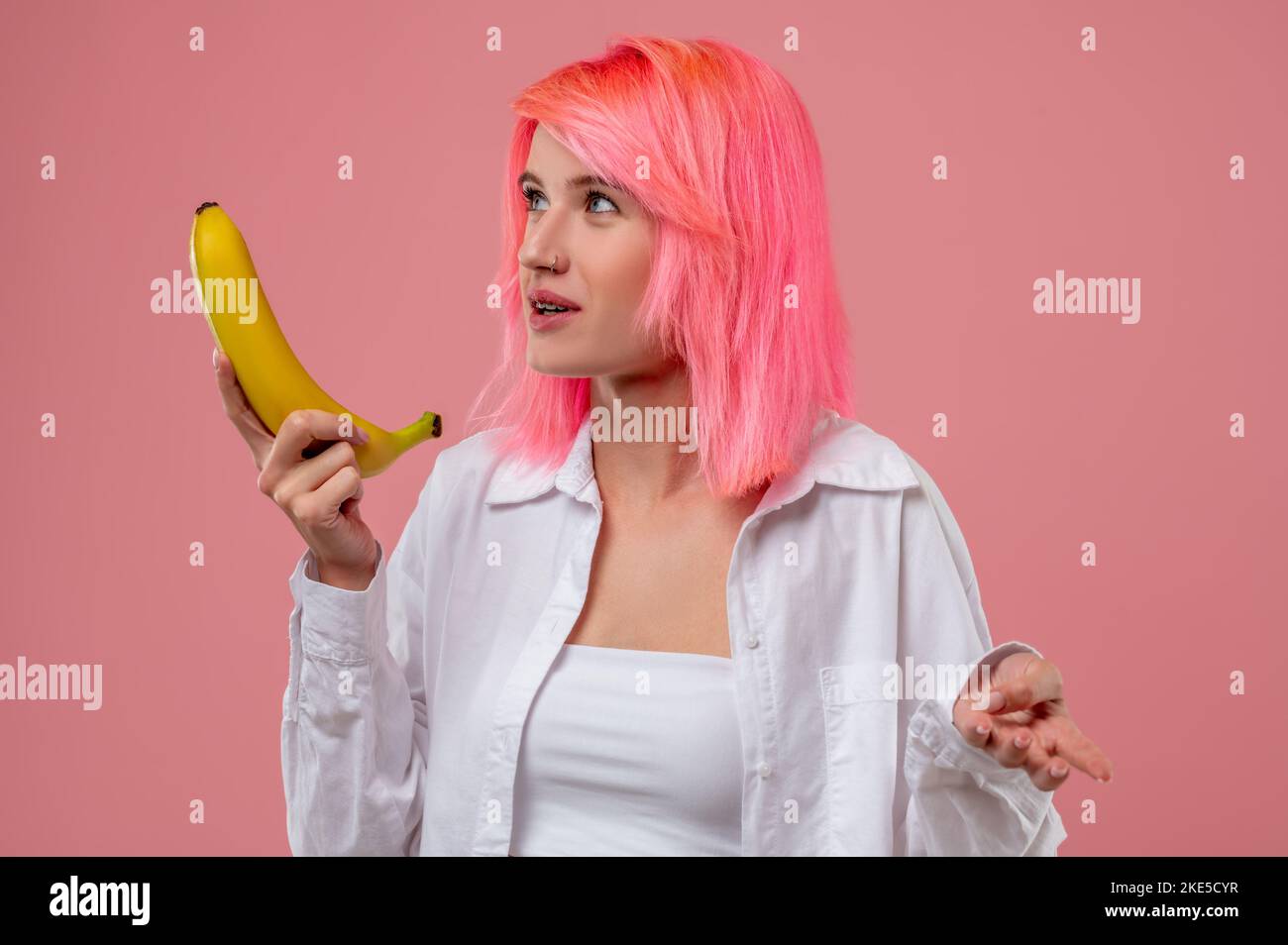 Young pink-haired woman speaking into the fruit microphone Stock Photo ...