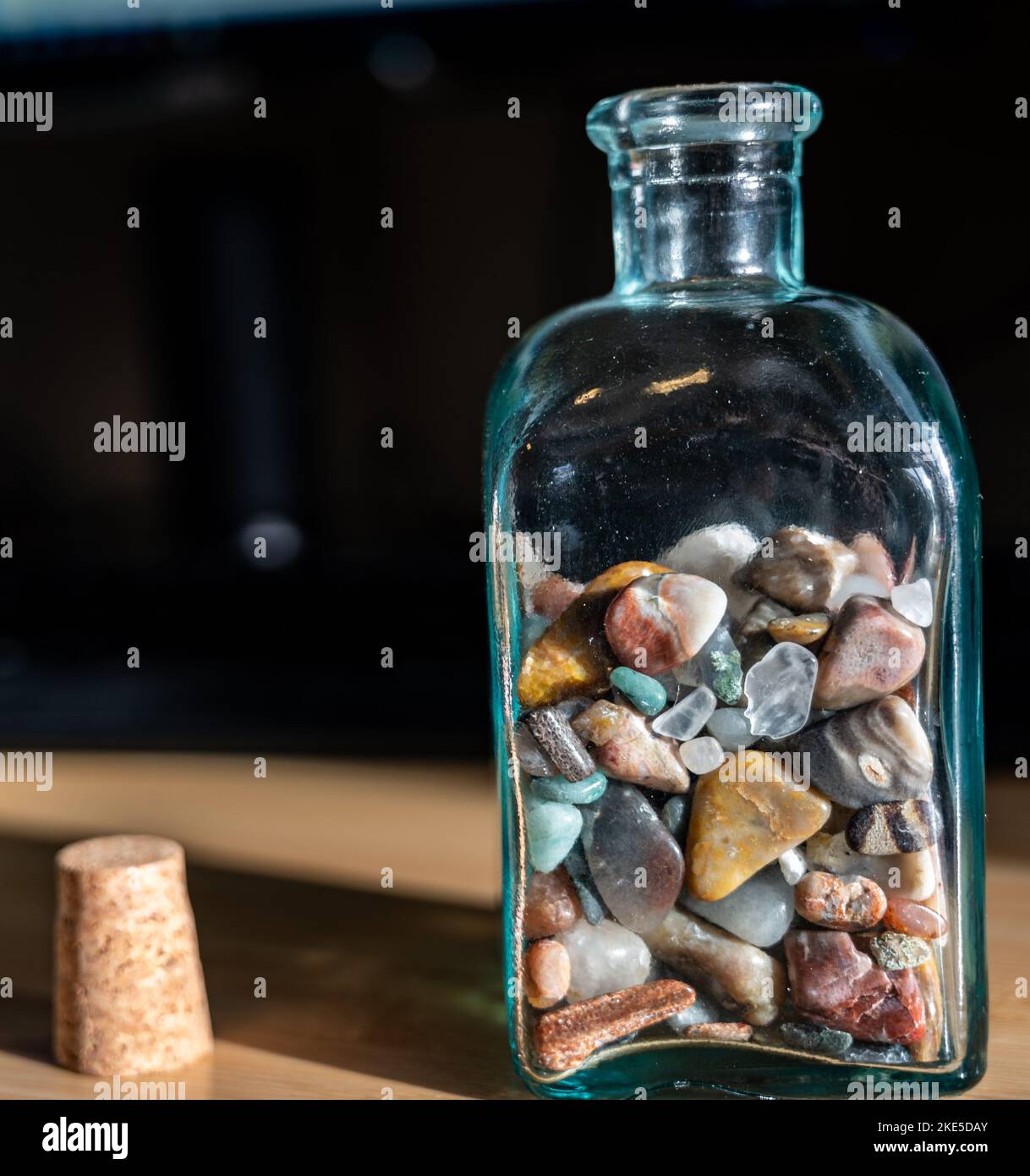 Glass bottle half full of rounded pebbles and rocks Stock Photo - Alamy