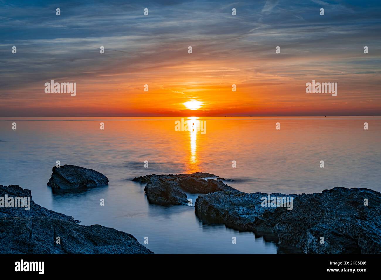 Sun falling into the water Stock Photo - Alamy