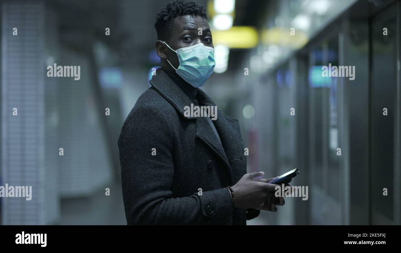 Black man standing at subway platform wearing coronavirus face mask ...
