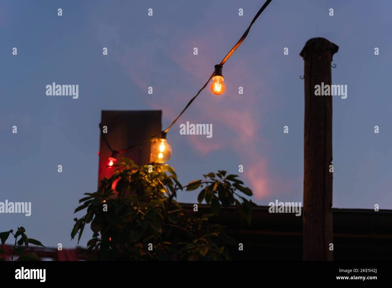 A beautiful evening view with shiny lamps hanging from a wire in cloudy ...