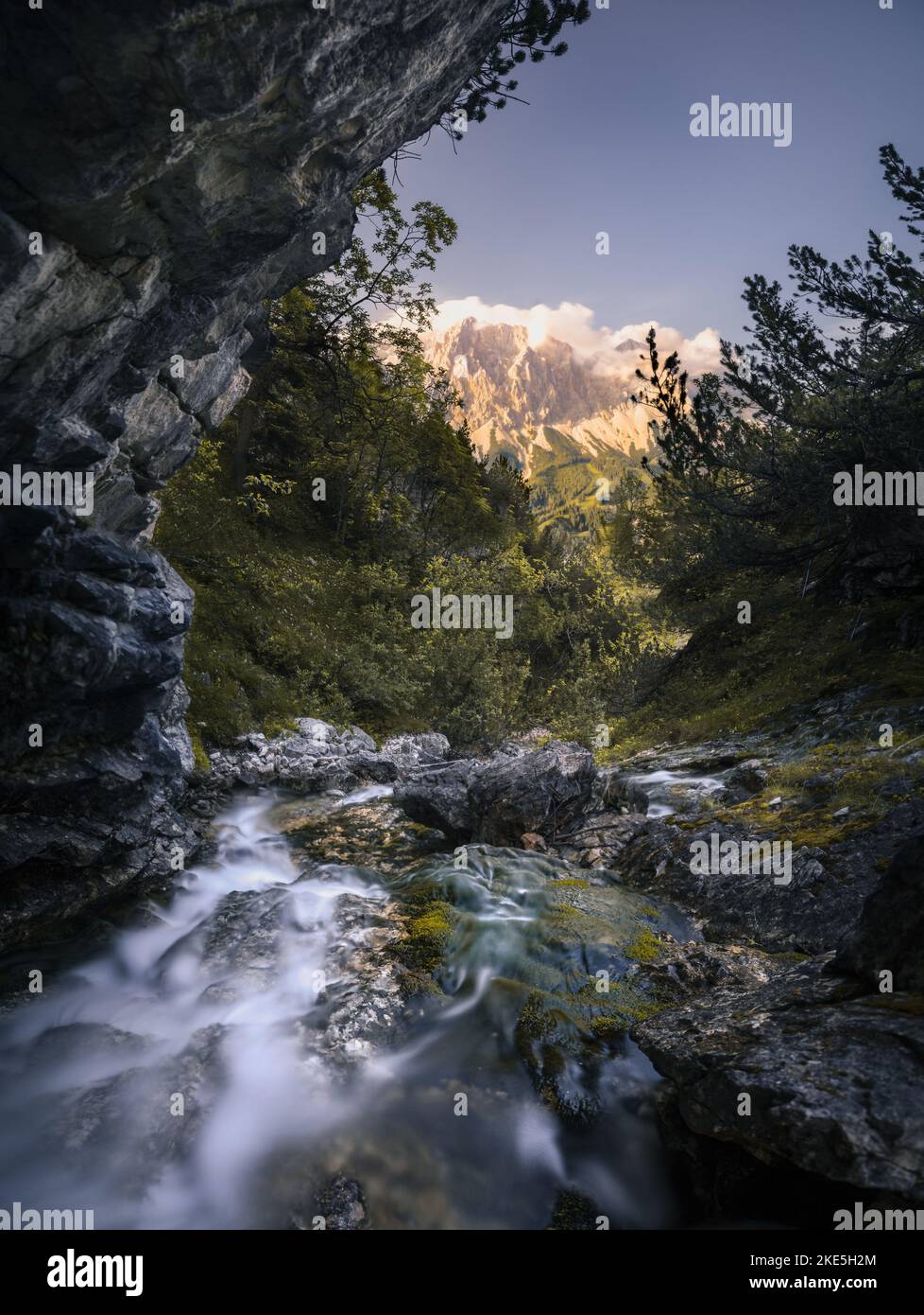 A scenery of a hidden stream flowing towards Zugspitze Mountain in the ...