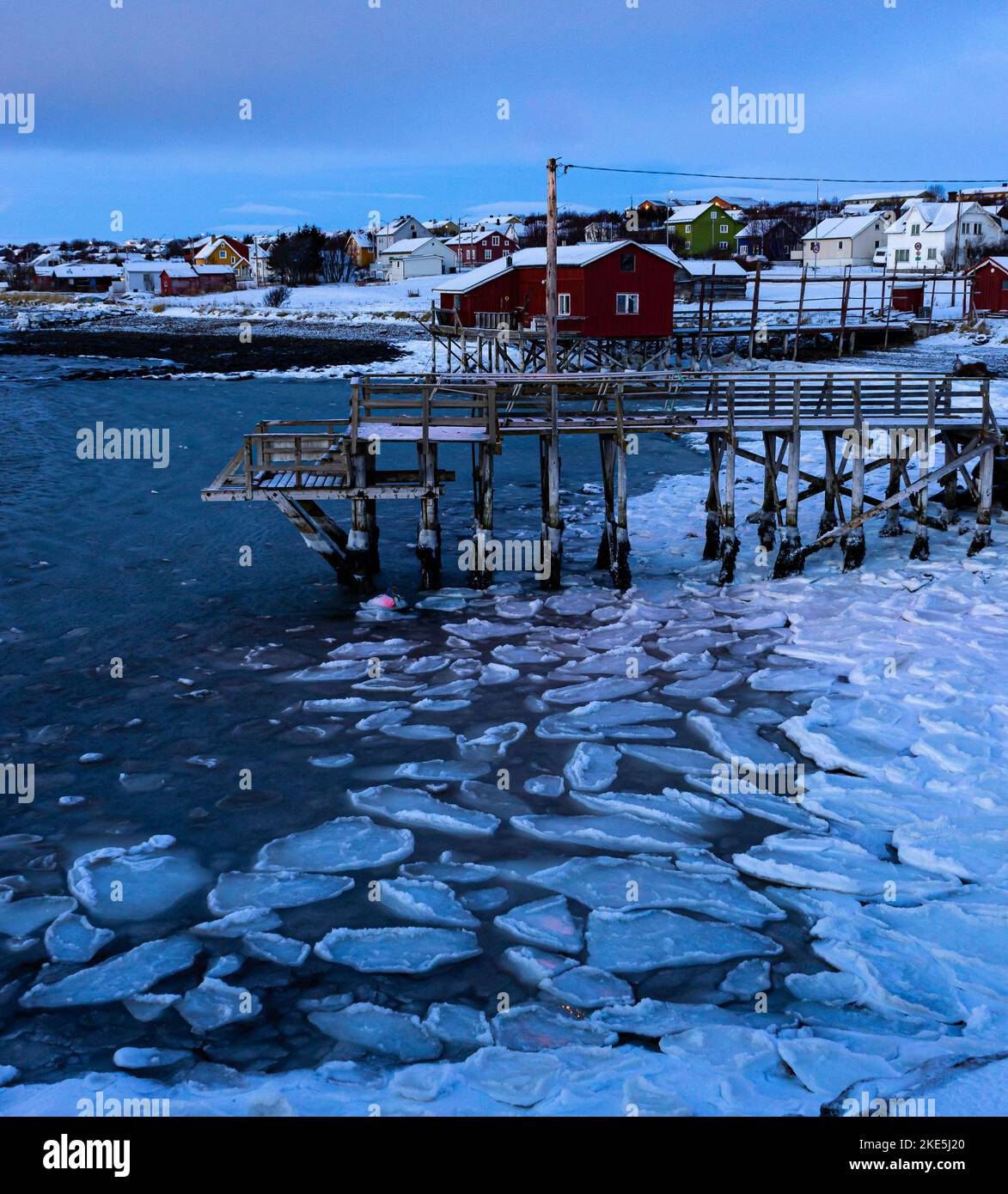 The frozen shore with a wooden pier of the Vadso village Stock Photo ...
