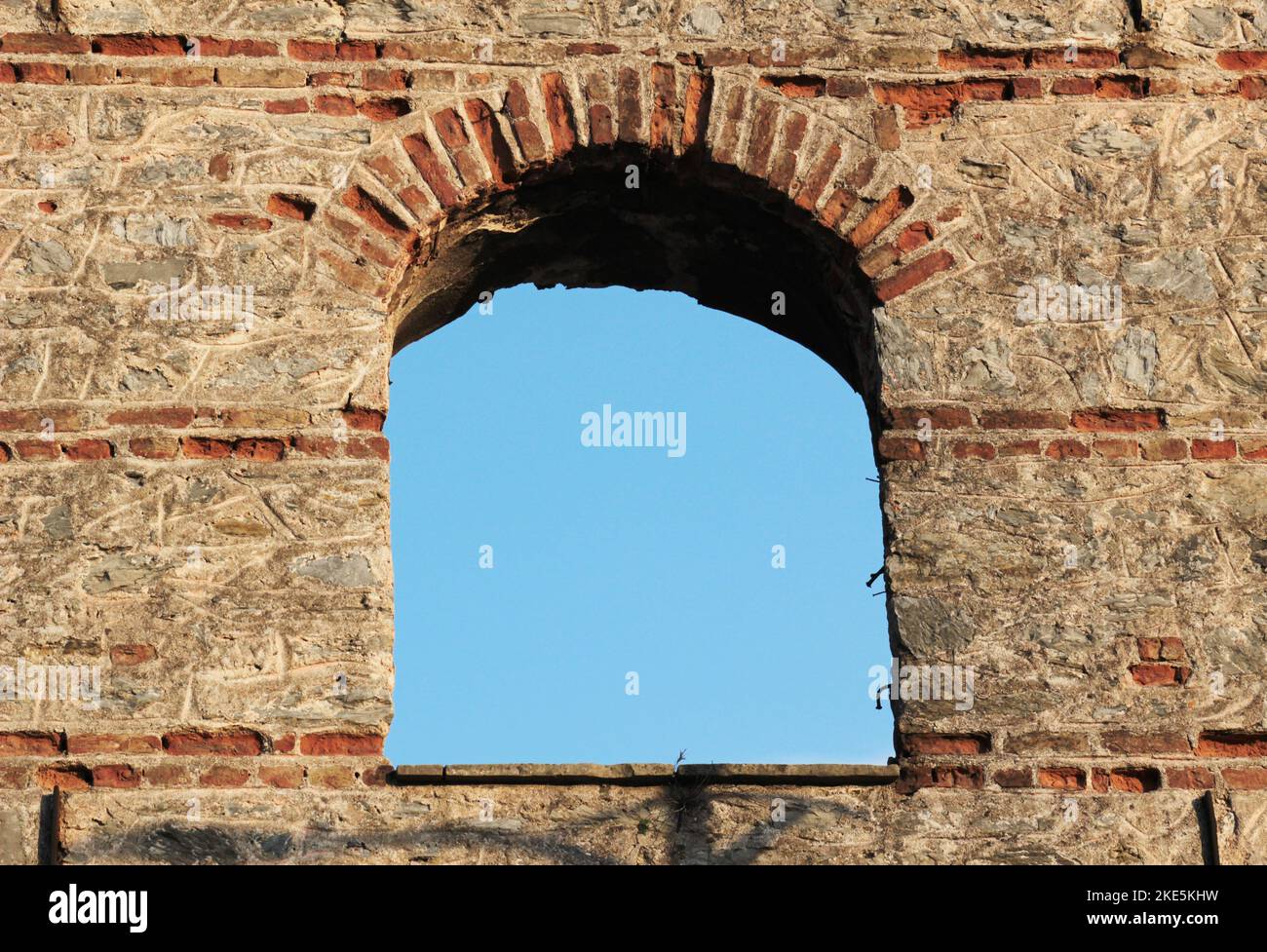 oval window in brick building opening to sky, aged round window, old ...