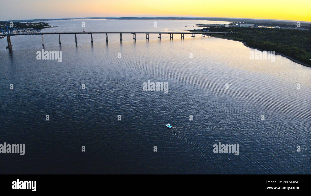 A soft orange sunset over the river with a bridge Stock Photo - Alamy