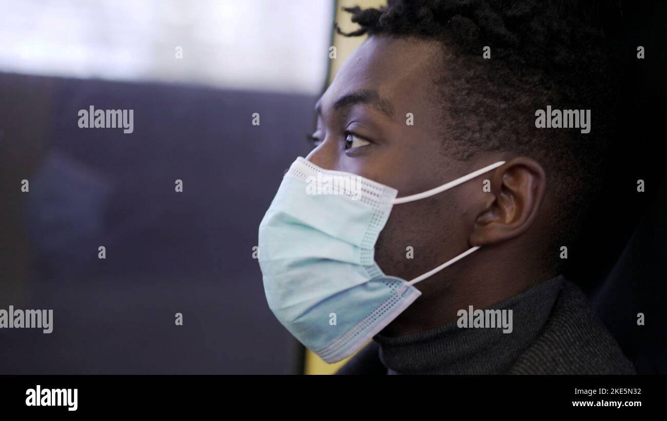 Black man commuter inside subway metro looking out window wearing covid ...