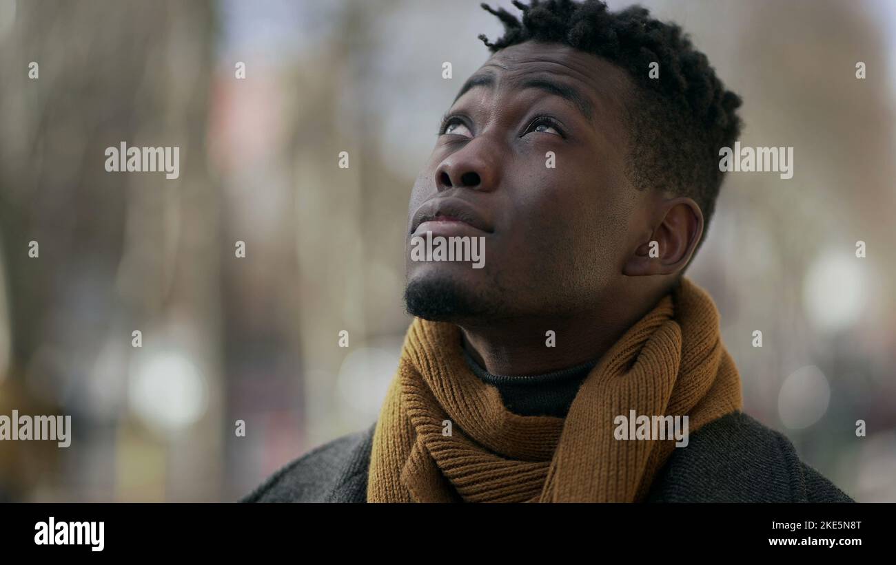 Black man squinting eyes while observing buildings Stock Photo - Alamy