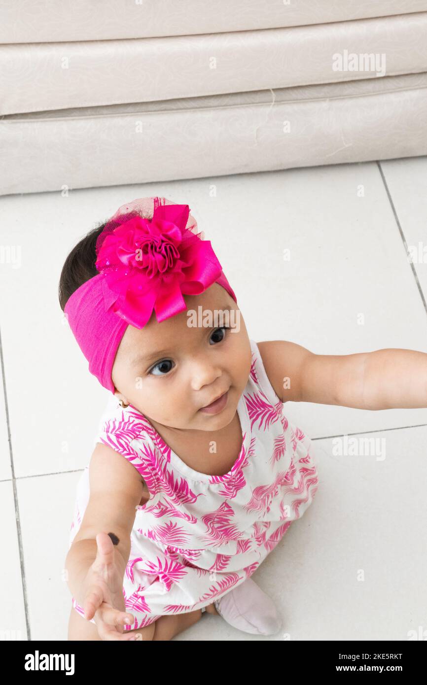 top view of a beautiful brunette baby girl asking her mother to hold ...