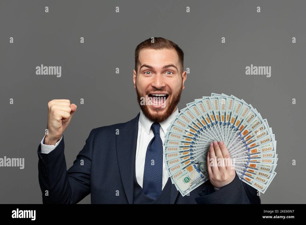 Handsome happy businessman in suit with fan of us dollars money ...