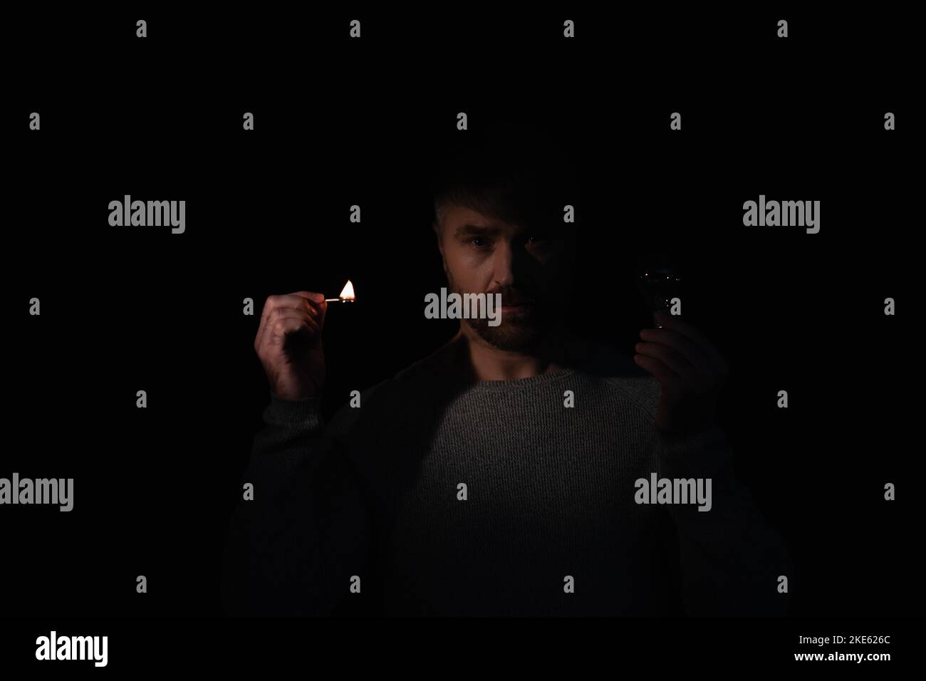 man with electric bulb and lit match looking at camera isolated on ...