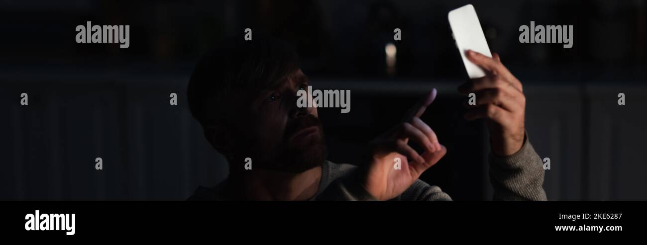 worried man pointing at smartphone while catching lost signal during ...