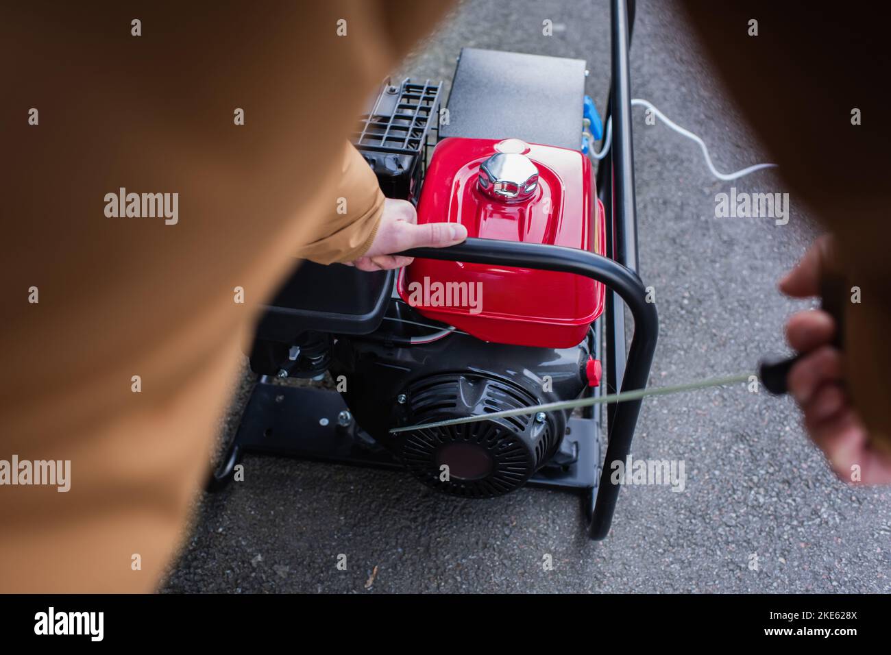 partial view of blurred man starting power generator outdoors Stock ...