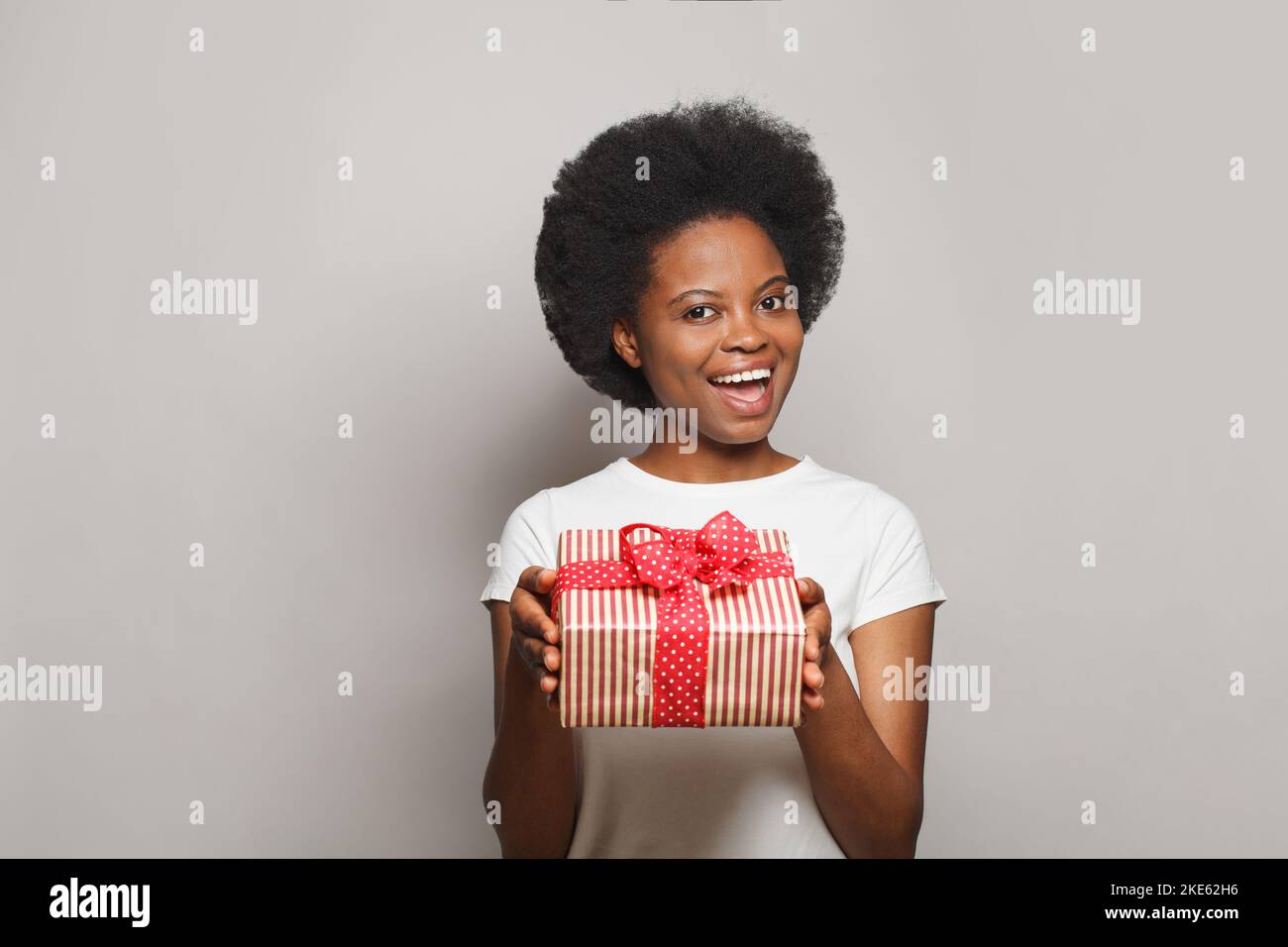 Positive woman giving gift box hi-res stock photography and images - Alamy